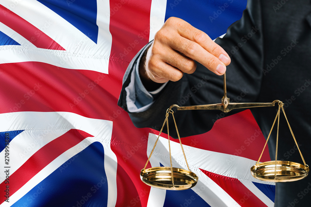 British Judge is holding golden scales of justice with United Kingdom ...