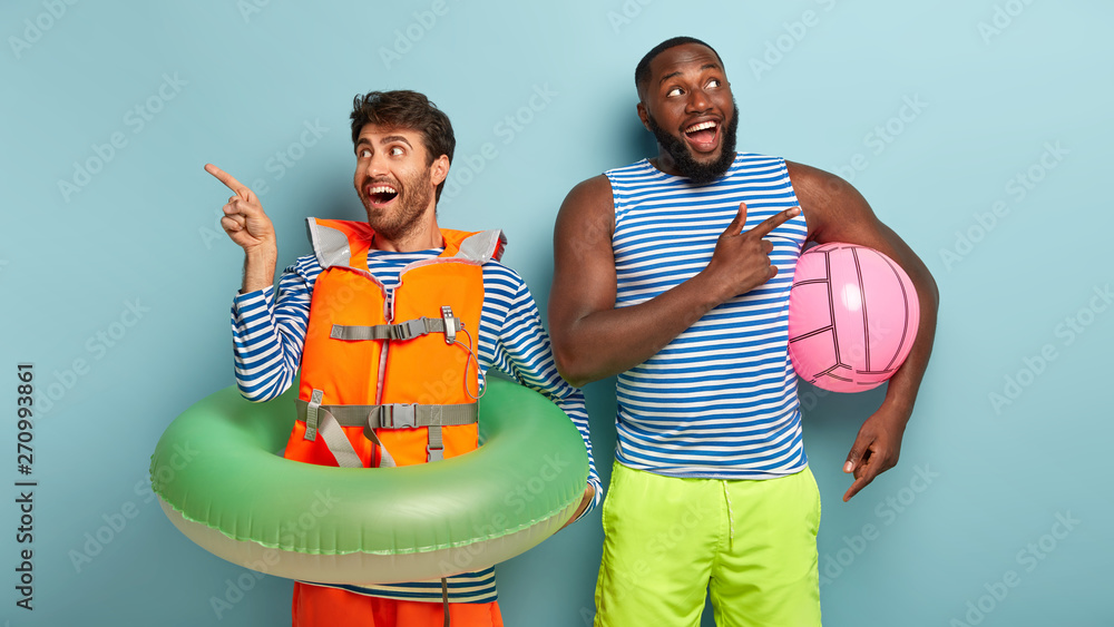 Summer time and recreation concept. Glad mixed race men point at ...