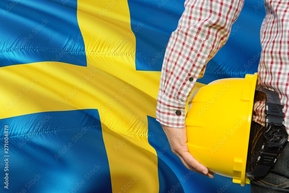 Swedish Engineer is holding yellow safety helmet with waving Sweden ...