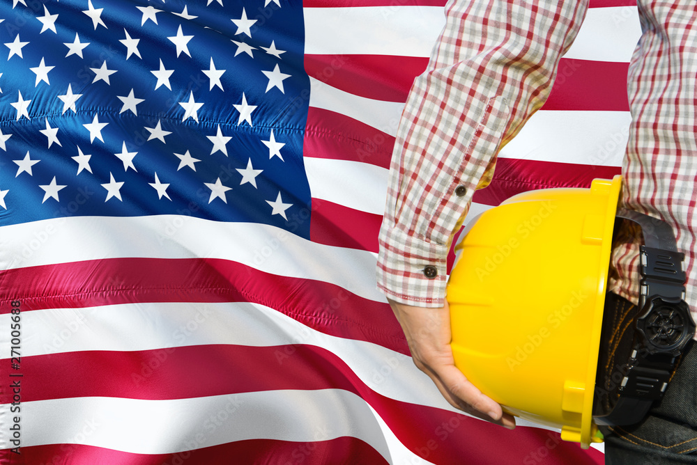 American Engineer is holding yellow safety helmet with waving United ...