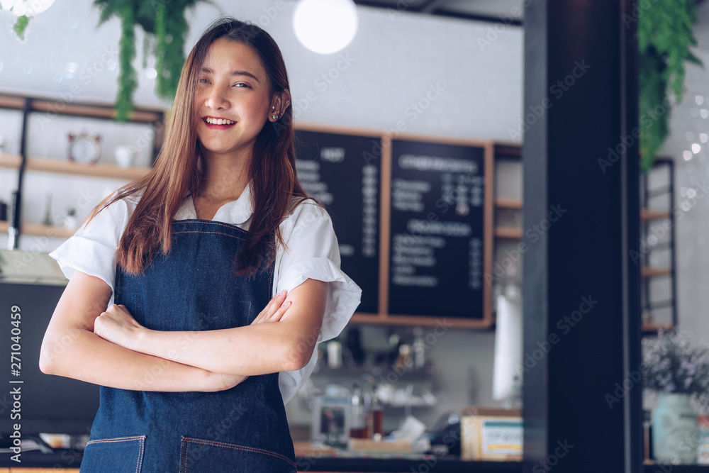 Pretty young asian waitress standing arms crossed in cafeteria.Coffee ...