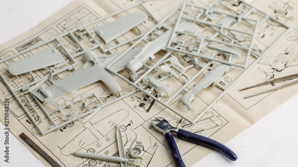 kit for assembling gray plastic airplane model on white bsckground ...