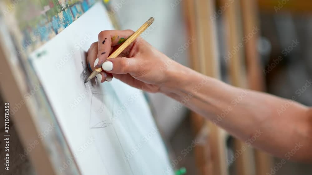 Close-up skilled female painter hand drawing sketch on white paper ...