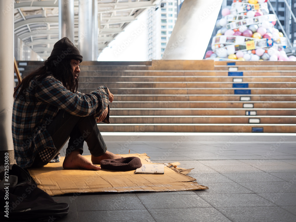 Homeless man sitting on walkway street in the city. Street patients and ...