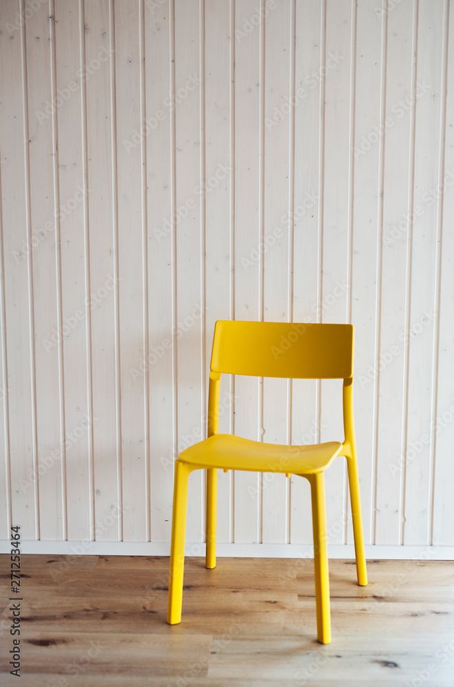 A plastic yellow chair against white wood texture background. Stock ...