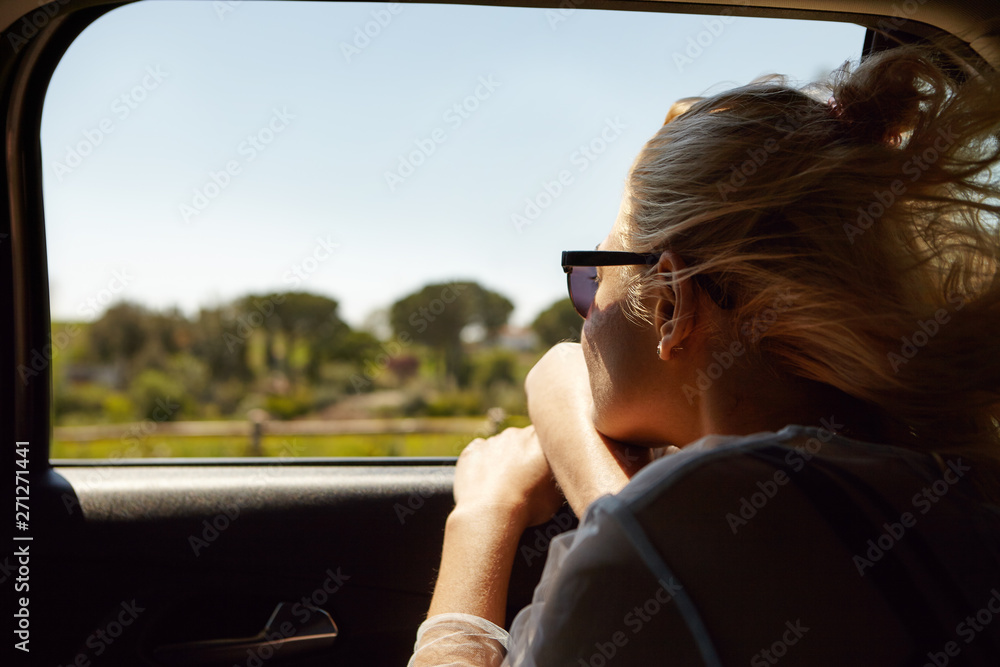 Back shot of attractive blonde European woman wearing sunglasses ...