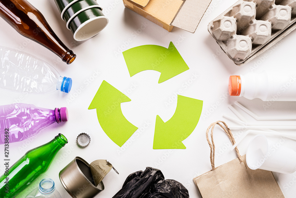 Top view of Different garbage materials with recycling symbol on white ...