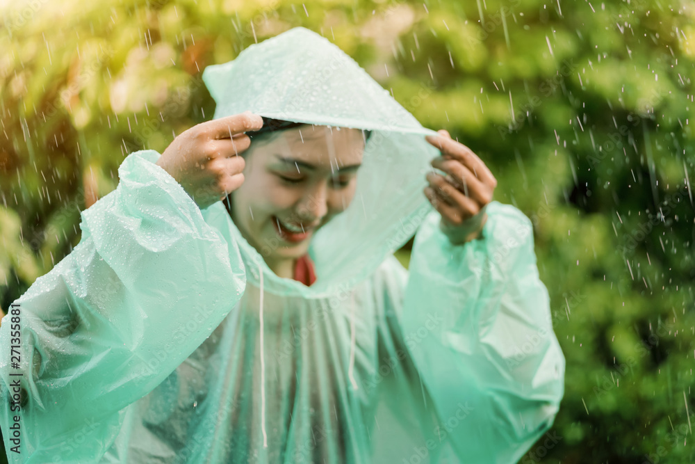 Young asian woman wearing raincoat in the rain, Rainy season. Stock ...