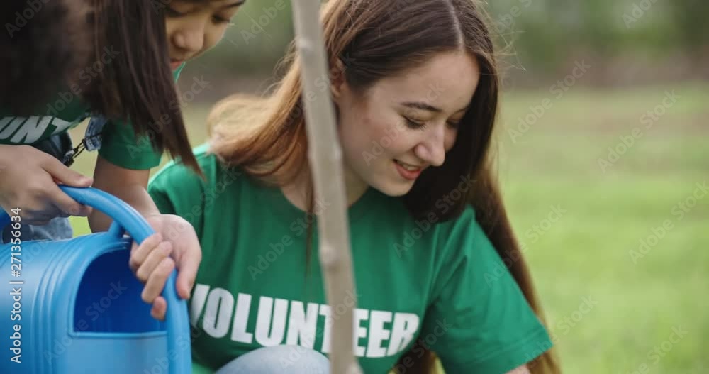Vidéo Stock Three volunteers of different age planting tree in park ...