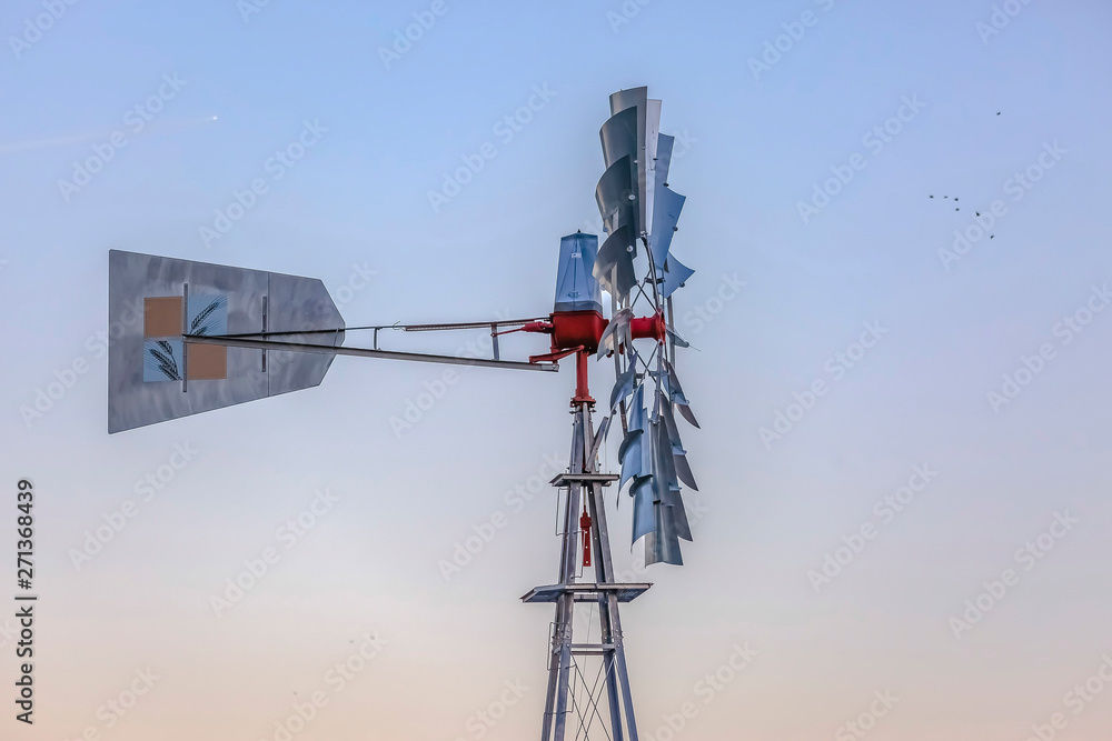 Side view of a windpump with the blades and tail connected to a red ...