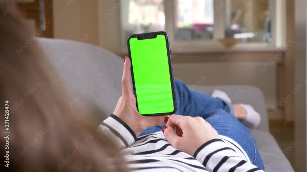 Closeup back view shoot of female watching video on the phone with ...