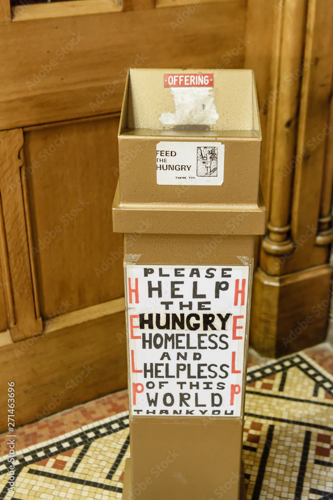 Collection box in a church asking for donations for the hungry ...