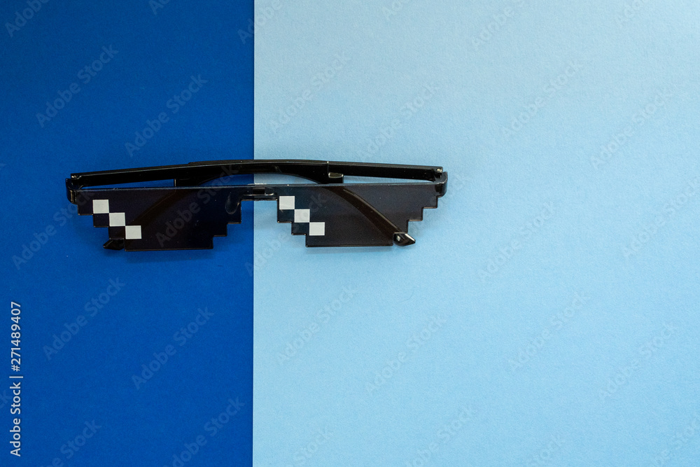 Pixel art glasses in black, isolated on a two tone dual blue background ...