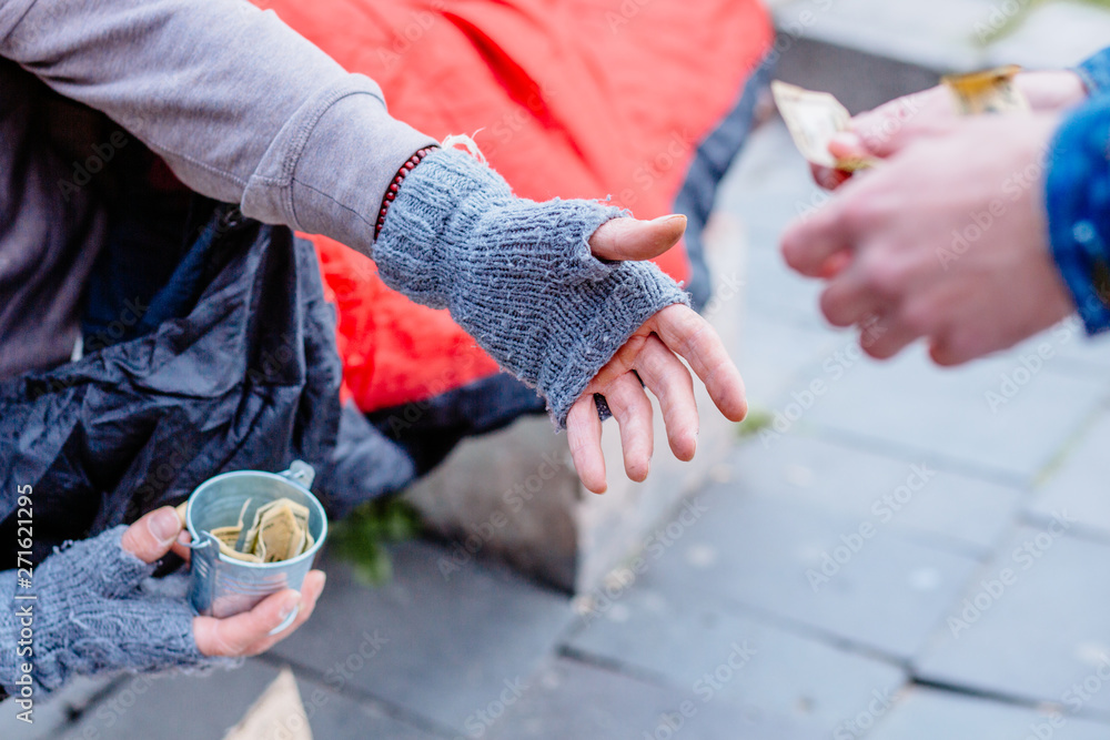 Unrecognizable man giving one dollar bill money to beggar o homeless ...