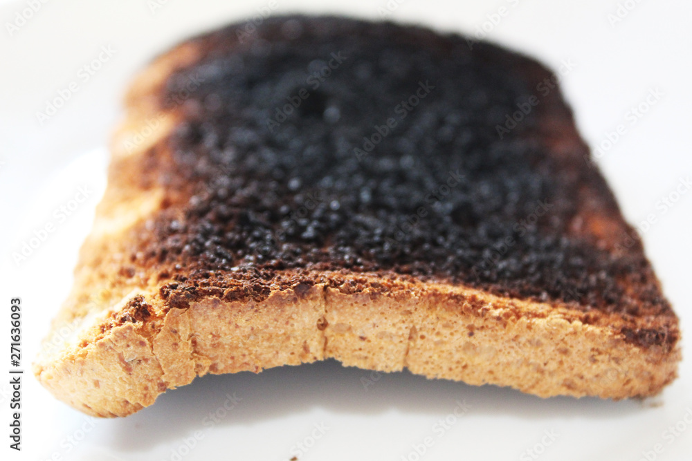 Tostada quemada negra sobre fondo blanco en boke Stock Photo | Adobe Stock