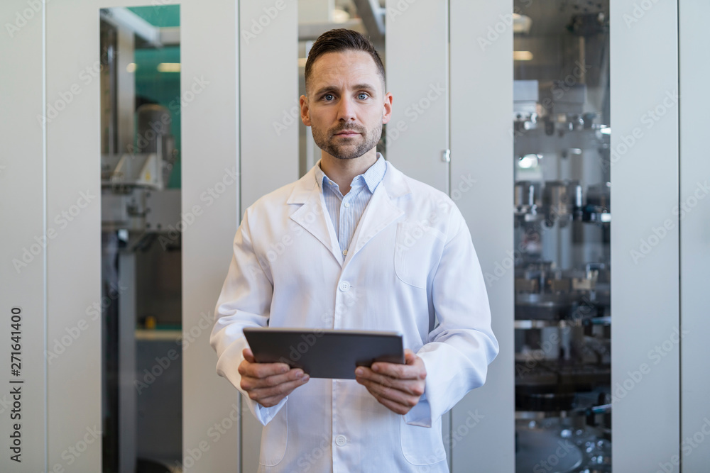 Portrait of man with tablet wearing lab coat in modern factory Stock ...