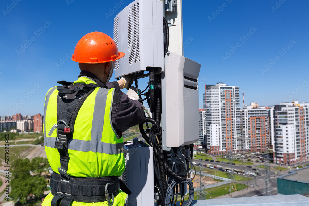 Telecommunication engineer in helmet and uniform installs ...