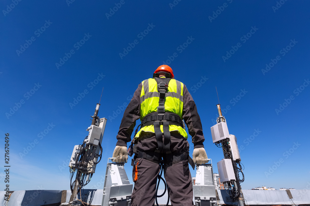 Foto de Telecommunication engineer in helmet and uniform holds ...