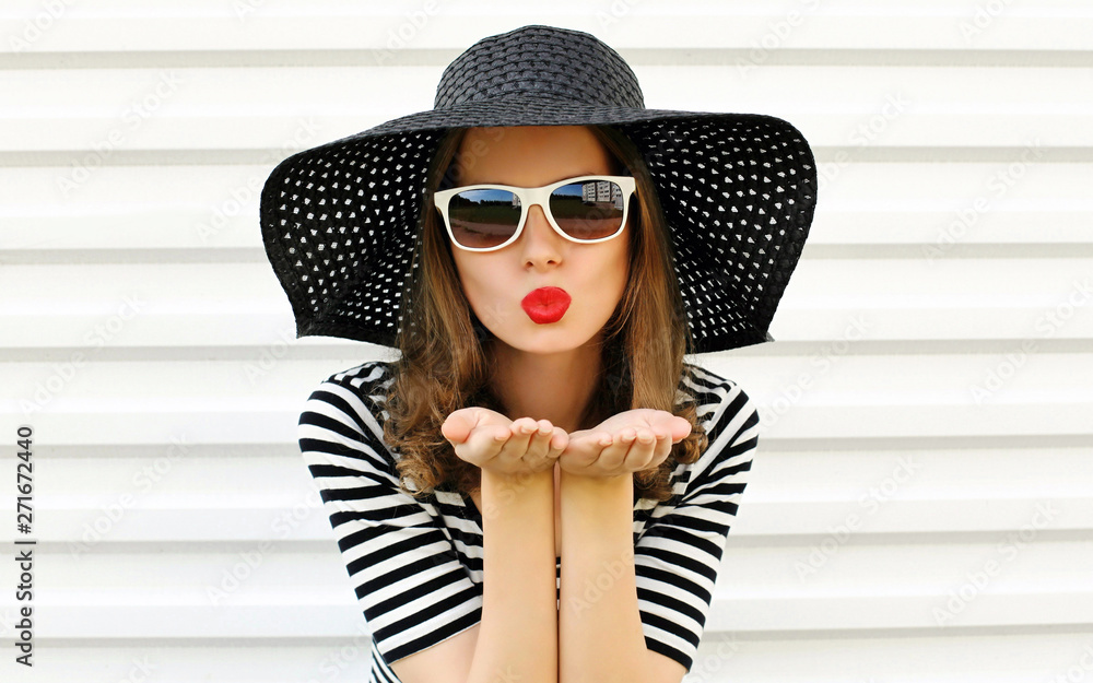 Portrait woman blowing red lips sending sweet air kiss in black summer ...