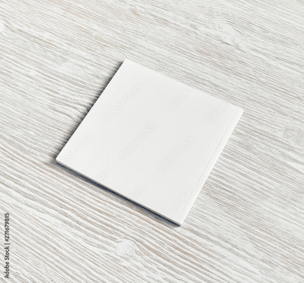 Blank square notebook on light wood table background. White paper ...