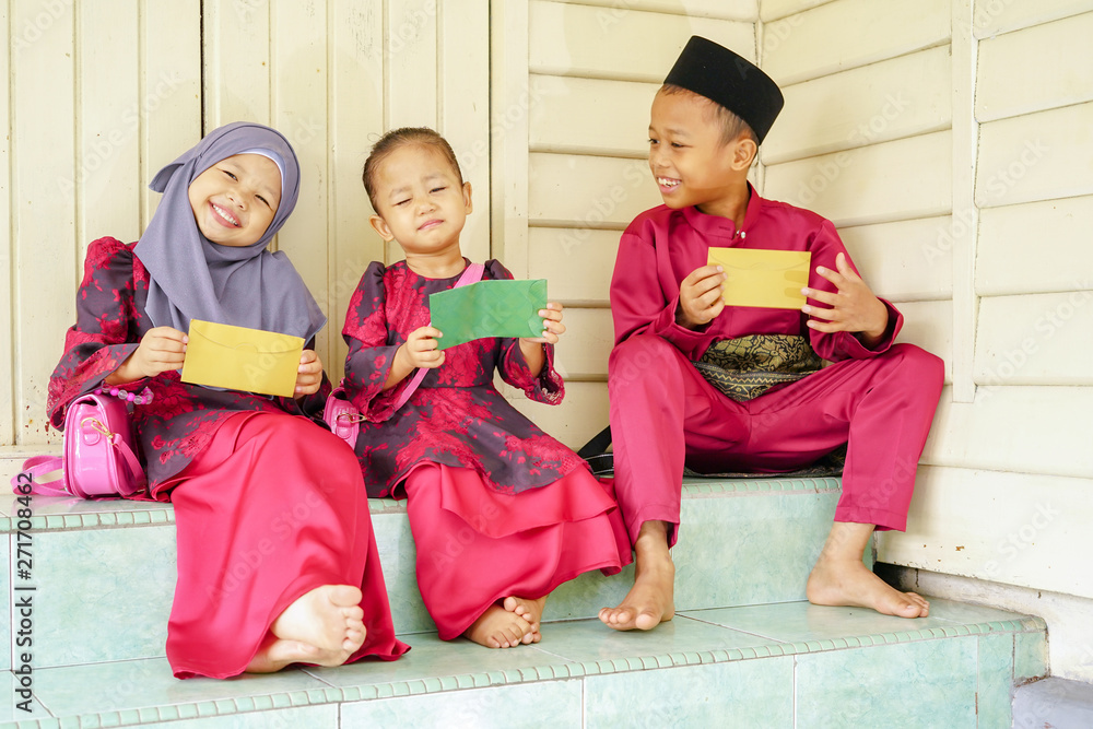 Three kids, happy siblings received money pocket or known as duit raya ...
