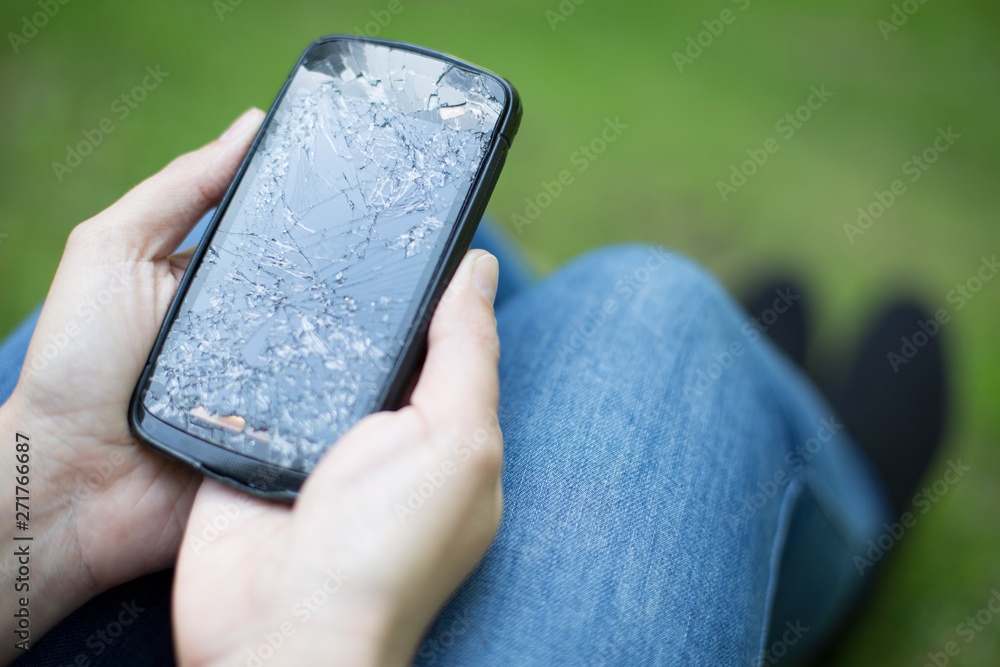 Broken glass screen smartphone in hand.Hand holding mobile phone with ...
