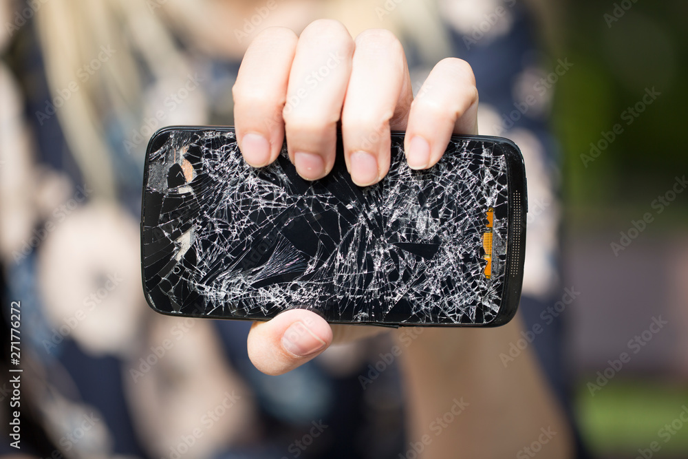 Broken glass screen smartphone in hand.Hand holding mobile phone with ...