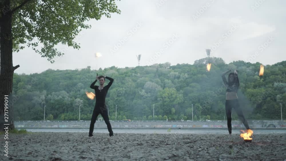 Young beautiful girl and handsome man in black clothes performing show ...