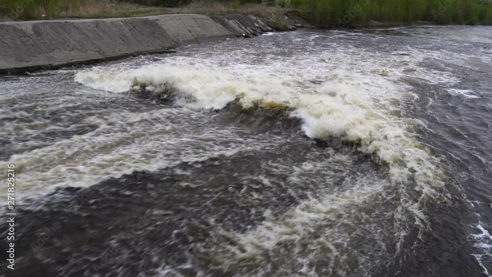 Turbulent flow of water with splashes and foam. Powerful raging river ...