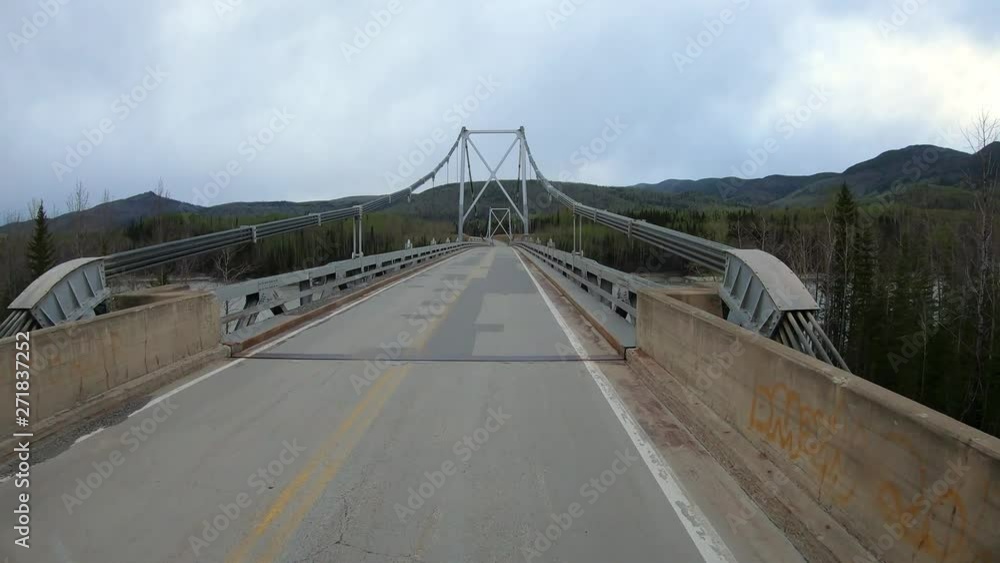 POV Driving the Alaska Highway over the suspension bridge over the ...