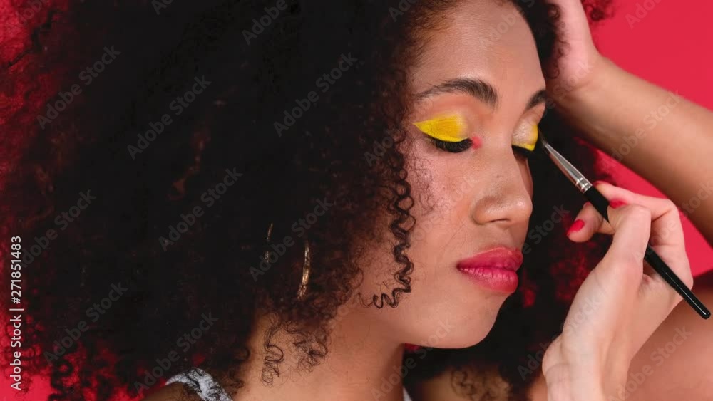 Vidéo Stock makeup artist brush paints the eyelids of a dark-skinned ...