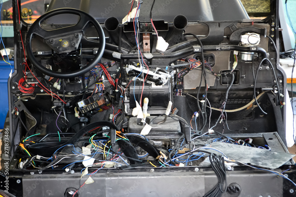 A lot of ravel multicolored wires from the car wiring lies in the cabin ...