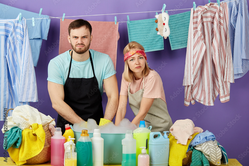 sad angry frowning couple washing clothes by hands, family doing ...