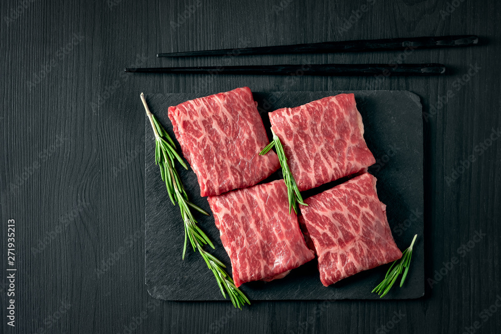Sliced wagyu marbled beef for yakiniku on plate on black background ...