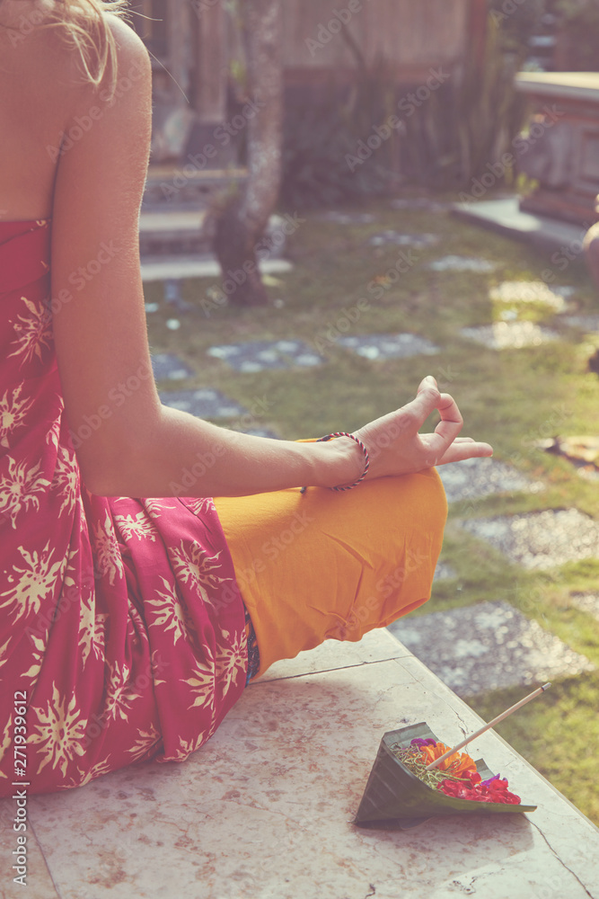 Woman holding canang sari - offering for Gods and praying. Balinese ...