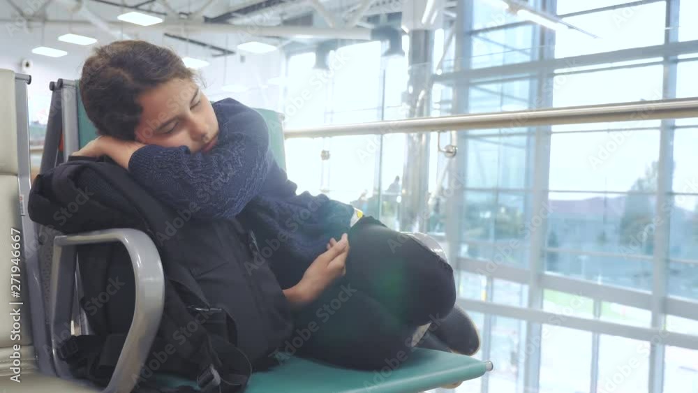 Vidéo Stock Tired girl teen traveler sleeping on the airport waiting ...
