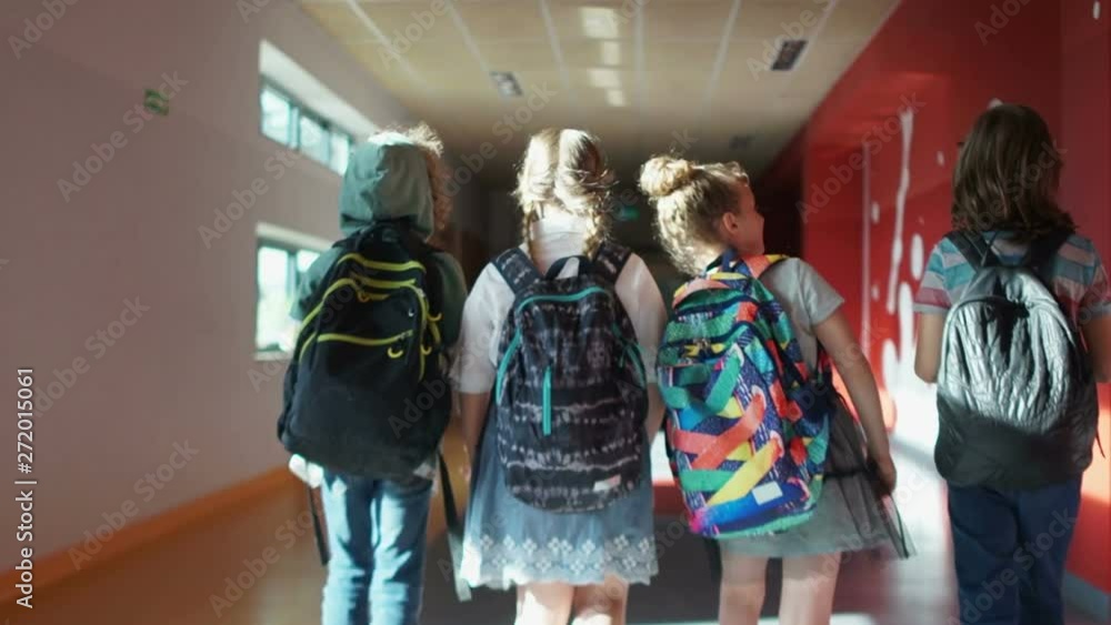 Back to school. Back view. Pupils go through the school corridor. Two ...