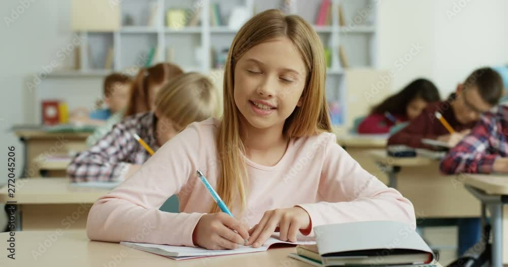 Portrait of the Caucasian teen beautiful blond girl writing in the ...
