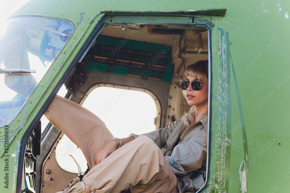 Female pilot in cockpit of helicopter before take off. Young woman ...