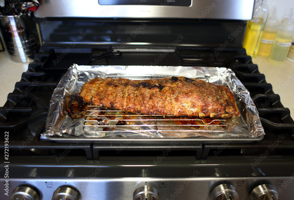 Rack of St. Louis cut style ribs resting in a baking tray on the stove ...