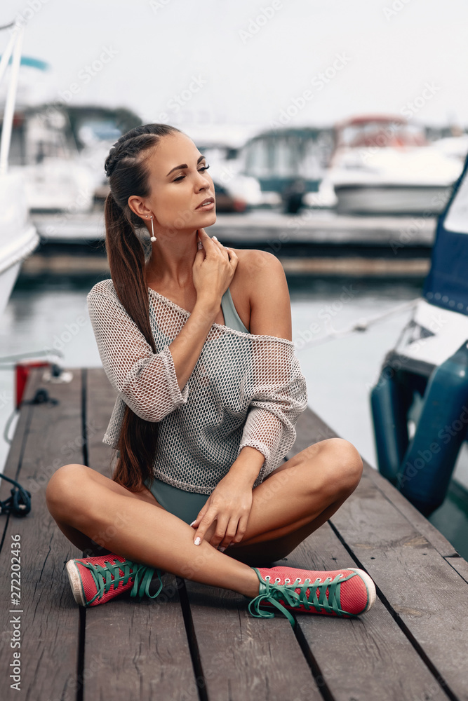 Elegant woman in a net shirt with perfect body posing for the camera on ...
