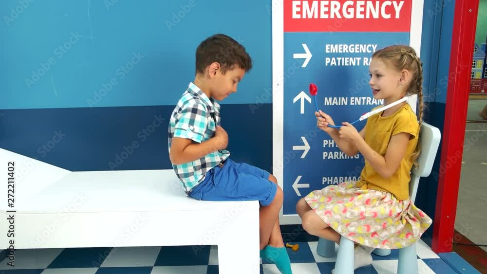 Two children playing doctor in playroom. Little girl doctor examining ...