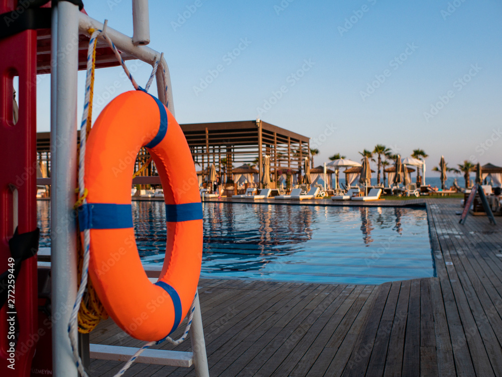 Orange lifebuoy near public swimming pool On a blurred background, a ...