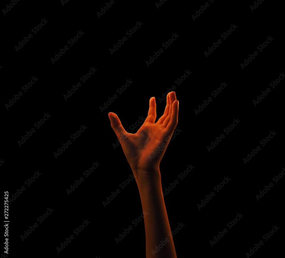 Isolated hand reaching to grab some source of light in the black ...