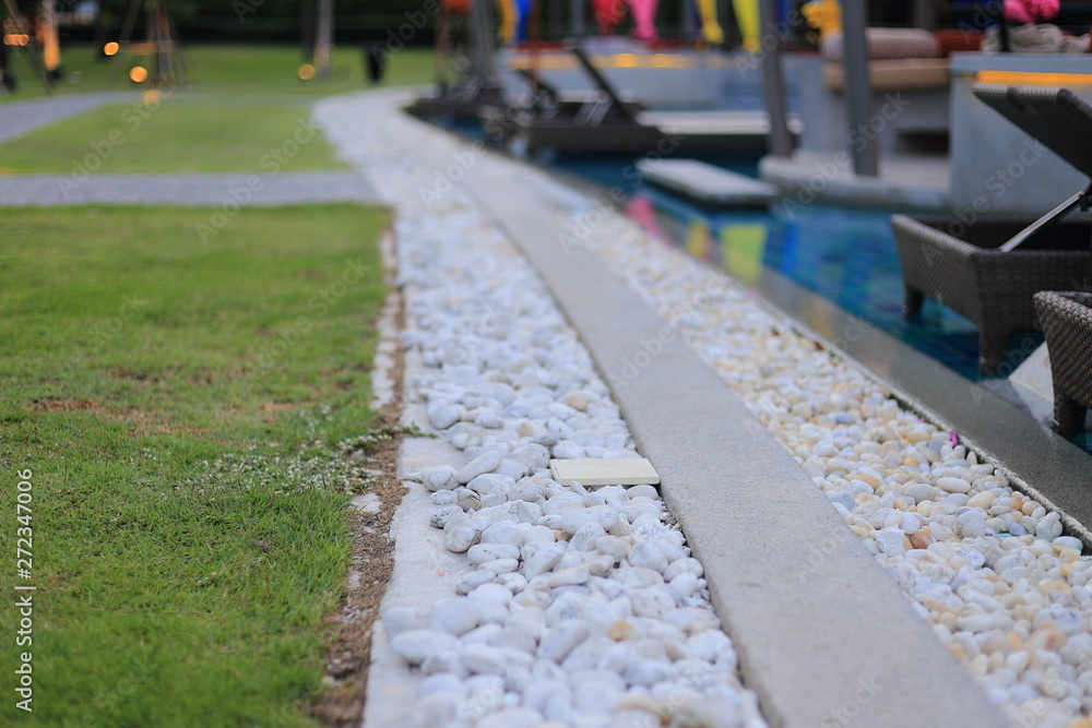 swimming pool drainage system grating covered with round white river ...