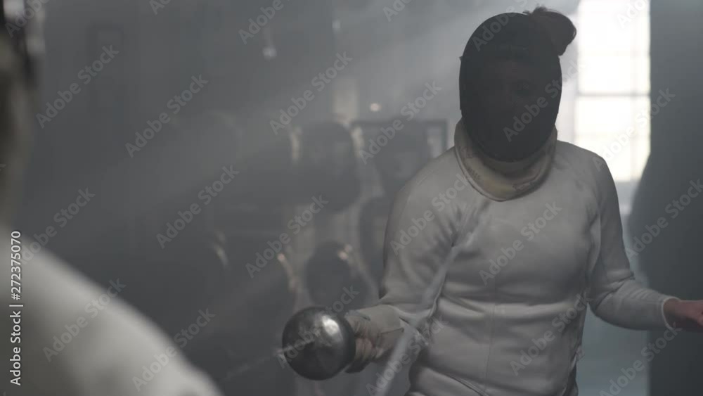 Over the shoulder slow motion shot of a male fencer training with his ...