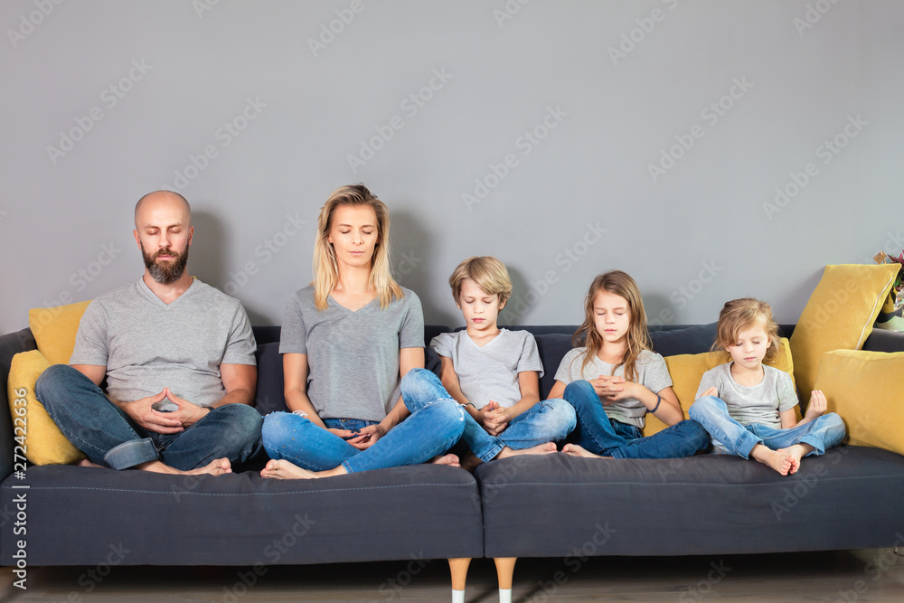 Family sitting in meditation. Father and mother with children sitting ...