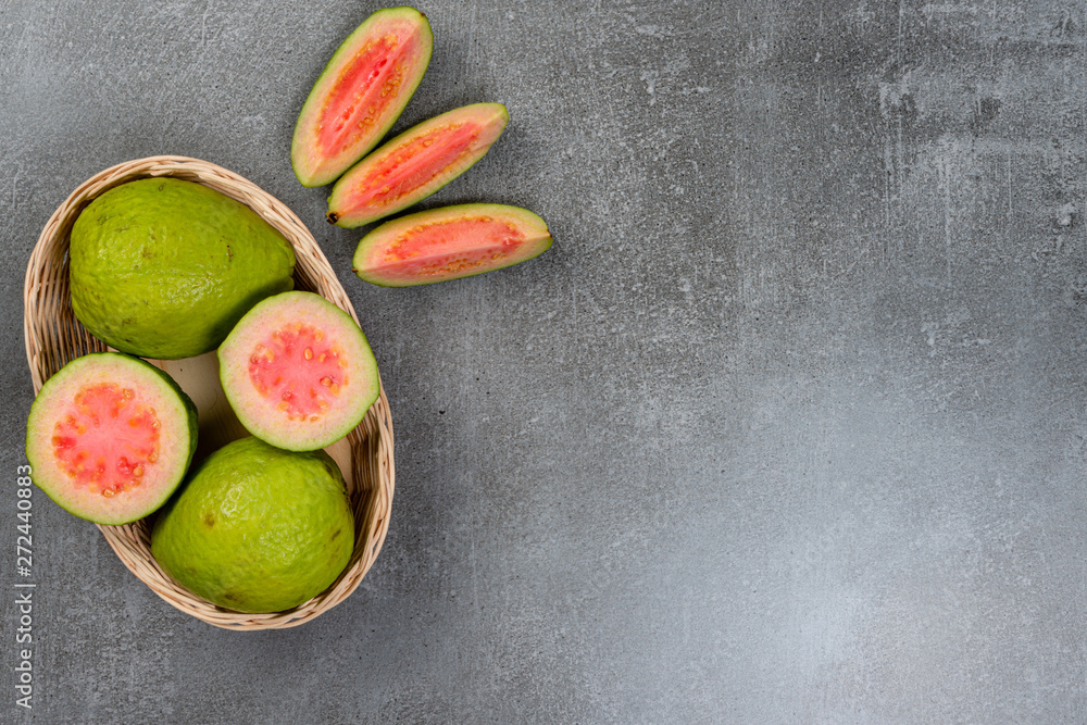 Pot with red guavas on concrete background and towel. Concrete texture ...