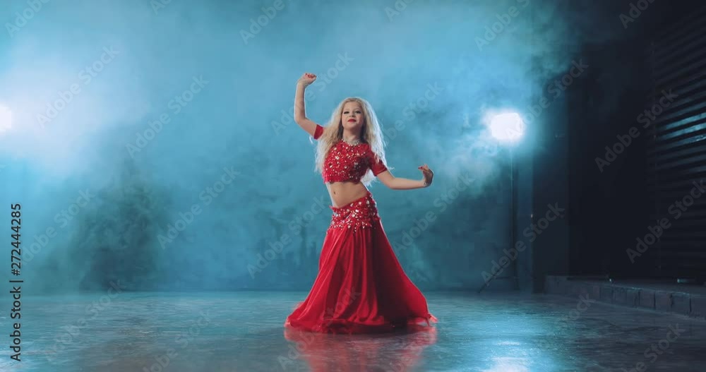 Beautiful blonde girl doing shaking belly and flowing movements with ...