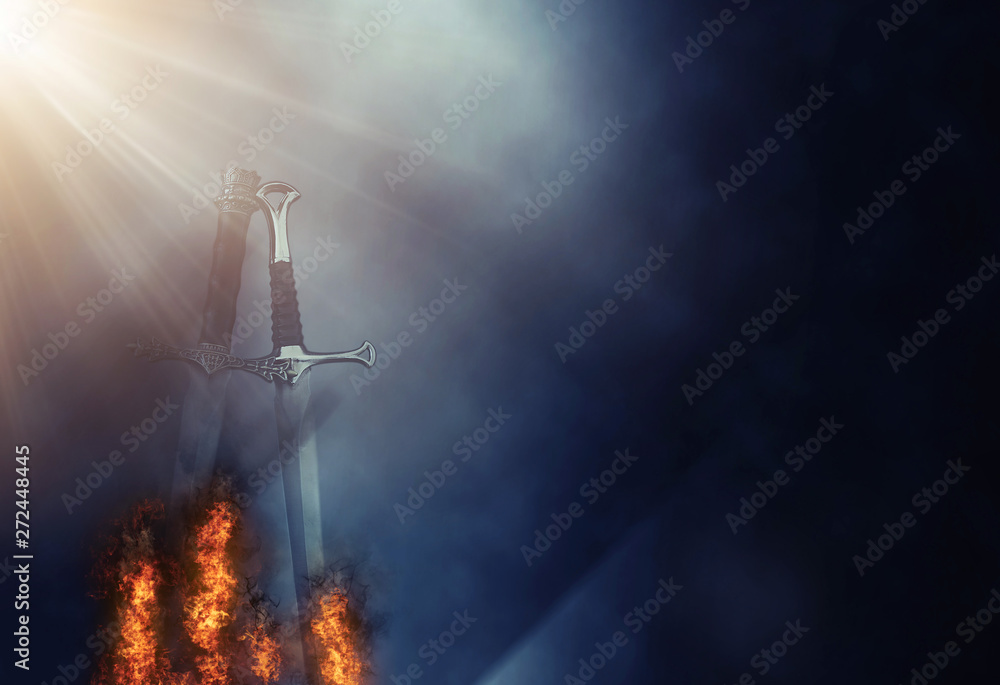 mysterious and magical photo of silver sword with fire flames over ...